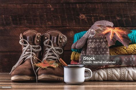 니트 접힌 스웨터 따뜻한 장갑 겨울 부츠와 가을 단풍나무가 나무 배경에 나뭇잎을 남깁니다 겨울과 가을 옷 못생긴 크리스마스 스웨터 따뜻하고 편안한 옷 겨울에 대한 스톡 사진