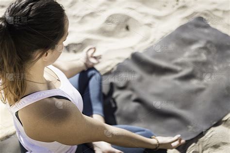 迷人的女人在海滩上做瑜伽