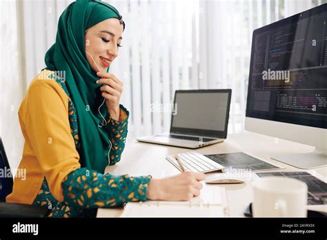 Happy Young Asian Freelance Software Developer Talking On Phone With