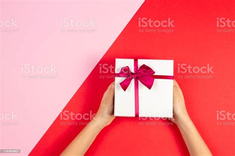 빨간과 분홍색 배경에 리본 선물 선물 상자를 들고 아이 손 크리스마스 어머니의 날 발렌타인 데이 생일 축하 가족에 대한 스톡