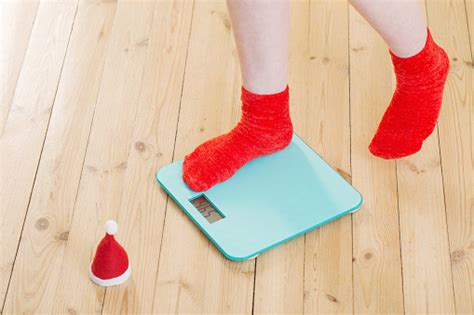 나무 바닥에 크리스마스 산타 모자와 빨간 양말에 체중 제어를위한 전자 비늘에 서 여성 발 1월에 대한 스톡 사진 및 기타 이미지