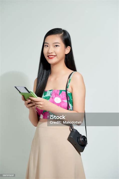 저렴한 항공편 개념 흰색 스튜디오 벽에 서서 티켓과 여권을 들고 기뻐하는 젊은 여성 관광에 대한 스톡 사진 및 기타 이미지