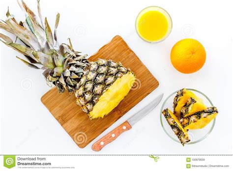 Pineapple Juice In Glass Near Slices Of Pineapple And Orange On White