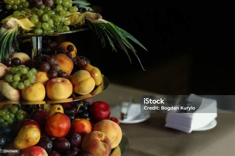 결혼식 피로연 디저트 테이블 클로즈업 갈색 식탁보 배경 복숭아 포도 파인애플 배 식사에서 맛있는 건강 한 과일 타워 결혼식