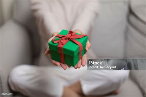 집에서 남자에게 크리스마스와 새해 선물 상자를주는 행복한 여자 가족 Xmas 축하 선물을 받는 사람 25 29세에 대한 스톡