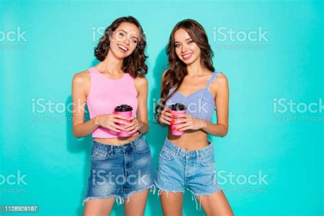 세로 2 멋진 아름 다운 세련 된 그녀의 레이디 잡고 뜨거운 음료 손 팔 친구 입고 그녀 색 반짝이 청바지 데님 반바지 탱크 탑