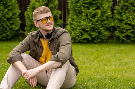 Premium Photo Portrait Of Young Man Sitting On Grass