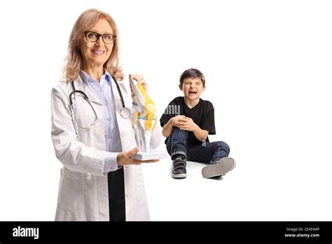 Boy Sitting On The Floor In Pain Holding His Knee And Doctr Holding A