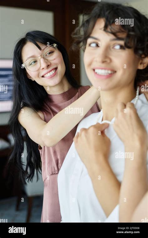 Happy Young Brunette Woman Helping Her Sister In White Silk Bathrobe