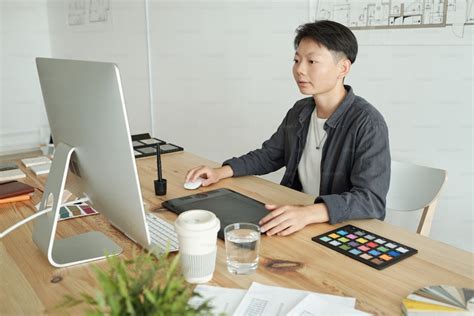 Foto De Joven Diseñadora China Sentada Frente Al Monitor De La