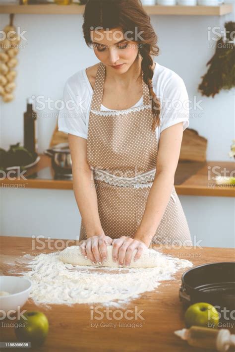 부엌에서 피자 또는 수제 파스타를 요리하는 젊은 갈색 머리 여자 나무 테이블에 반죽을 준비하는 주부 다이어트 음식 및 건강 개념