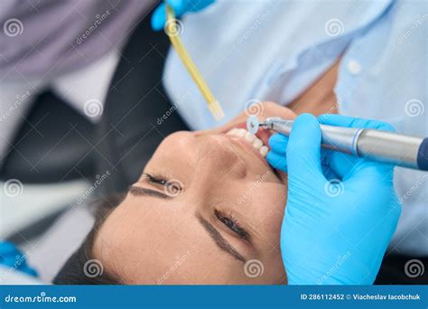 Close Up Dentist Smoothing And Polishing Uneven Edges Of Female Patient