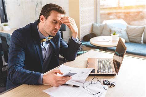 Concerned Businessman Looking At Mobile In Office Brainin Law Office