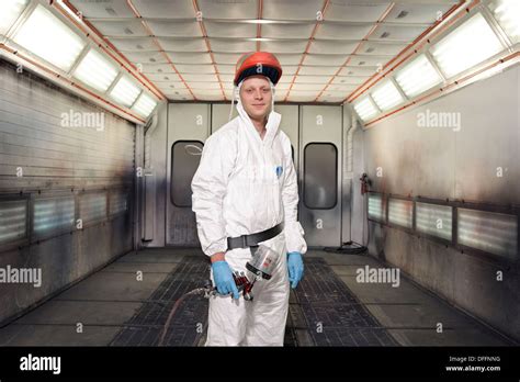 Car Spray Painter In Work Overalls With Spray Paint Gun At An Stock