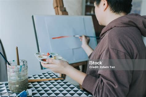 이젤에 그녀의 색상 팔레트 페인트 브러시와 예술 종이와 함께 집에서 그리는 아시아 중국 여성 예술가 Lifehack에 대한 스톡
