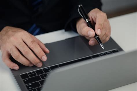 노트북 키보드에 입력하는 사람 노트북 작업을 하는 사업가는 동료에게 메시지를 입력하고 회의를 요약하기 위해 재무 정보 시트를 만들고 있습니다 프리미엄 사진