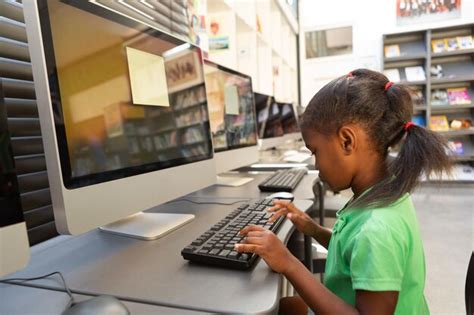 Premium Photo Schoolgirl Using Computer In The Library