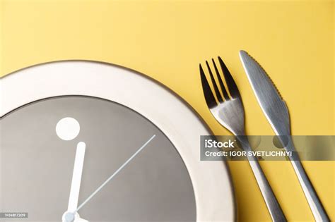 점심 시간 식사의 개념 화려한 노란색 배경에 칼과 시계포크 먹을 시간입니다 맨 위 보기입니다 공간을 복사합니다 플랫 레이 클로즈업 건강한 식품 개념 점심에 대한 스톡 사진