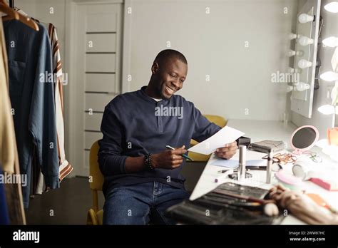 Portrait Of Smiling Black Man Reading Script While Preparing For