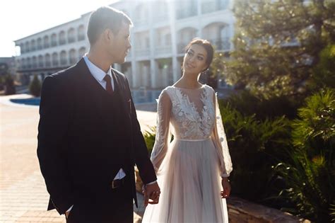 Premium Photo Newlyweds Tenderly Hug Kiss And Enjoy Each Other Walk