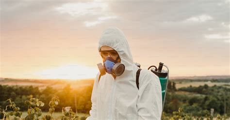 잡초 방제 산업 농업 테마입니다 과일 재배 농장에 독성 살충제 또는 살충제를 뿌리는 남자 화창한 날에는 자연스러운 하드 라이트 배경에 구름이 있는 푸른 하늘 사진