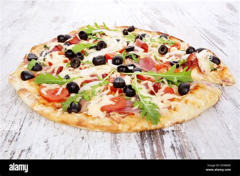 Delicious Pizza With Ham Black Olives Fresh Herbs And Melted Cheese