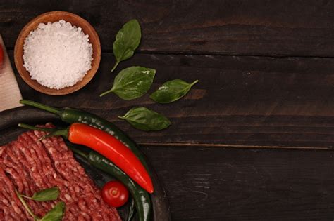 접시에 원시 다진 고기 토마토 후추 양파 향신료와 검은 바탕에 조미료와 햄버거에 대 한 재료 평면도 및 복사 공간 0명에 대한