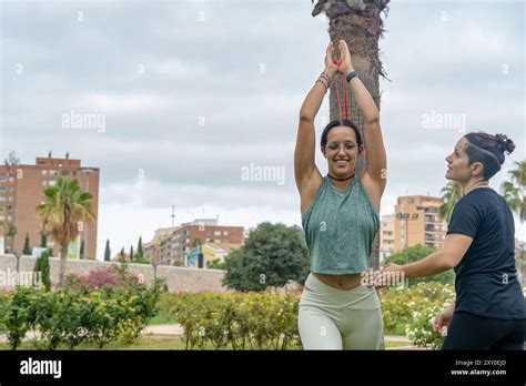Functional Outdoor Training Session Where Two Women Use Elastic Bands To Perform Resistance