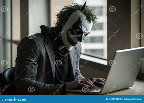 Hacker In A Hoody And A Scary Joker Mask Sitting In An Office