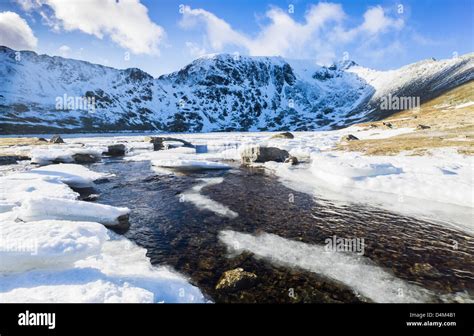 A Frozen Red Tarn With Striding Edge Helvellyn And Swirral Edge In The