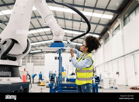 Engineer Examining Robotic Arm Machine In Warehouse Stock Photo Alamy