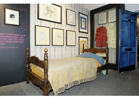 There Is A Bedroom With Pictures On The Wall And A Bed In Front Of It