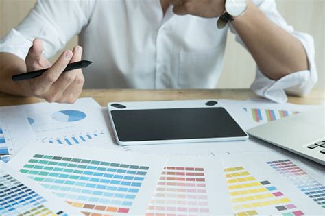 컴퓨터와 색상 견본 작업 젊은 그래픽 디자이너 현대 사무실에서 스타일러스 펜과 디지털 태블릿을 사용 하 여 창조적인 사람 작업 도구와 샘플 컬러 카탈로그를 사용 하 여