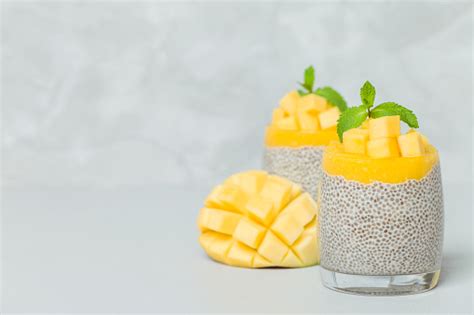Chia 씨앗 푸딩과 망고 그린 민트 잎으로 아름 다운 안경에 퓌 레와 신선한 익은 열 대 과일을 잘라 건강한 생활방식에 대한
