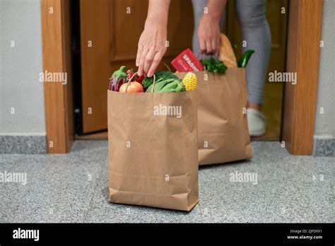 A Woman Picks Up A Bag Of Food At The Door Of Her House Coronavirus