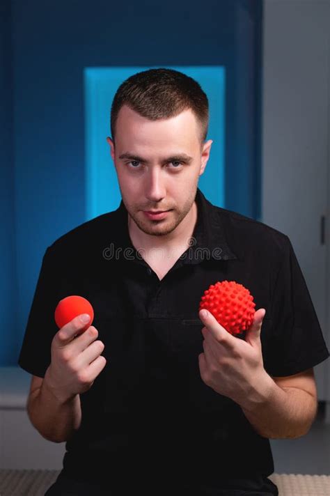 Attractive Caucasian Young Male Masseur Holding Two Massage Balls In