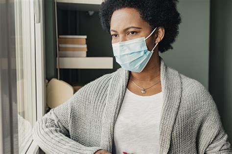 집에서 창에 의해 얼굴 마스크를 가진 아프리카 계 미국인 여성 40 44세에 대한 스톡 사진 및 기타 이미지 40 44세