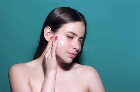 Beautiful Model Applying Cosmetic Cream Treatment On Face Facial