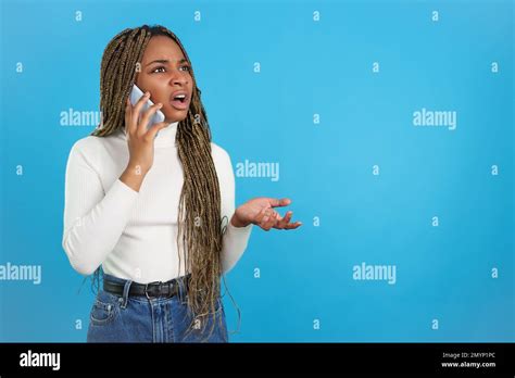 African Woman With An Expression Of Incredulity Talking With Mobile