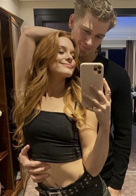 A Man And Woman Taking A Selfie In A Hotel Room With Their Cell Phone