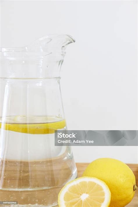 새콤하고 달콤한 감귤류를 얇게 썰어 레몬 물 레모네이드가 담긴 유리 주전자로 흰 벽 배경에 나무 쟁반에 올려 놓습니다 0명에 대한 스톡 사진 및 기타 이미지 Istock