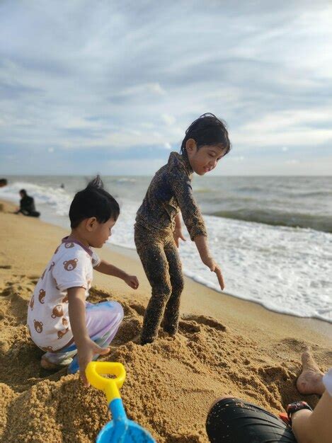 Premium Photo Side View Of Sibling Playing At Beach