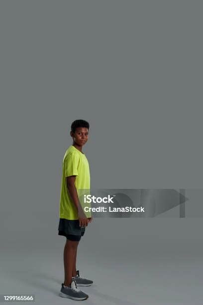 스튜디오에서 회색 배경을 통해 고립 된 포즈를 취하는 스포츠 옷을 입은 십대 아프리카 소년의 전체 길이 가냘픈에 대한 스톡 사진 및 기타 이미지 Istock