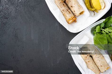 Tavuk Tantuni Durum 터키 요리 도너 케밥 플라스틱 팩 용기 배달 도시락 검은 색 어두운 돌 테이블 배경 평면도