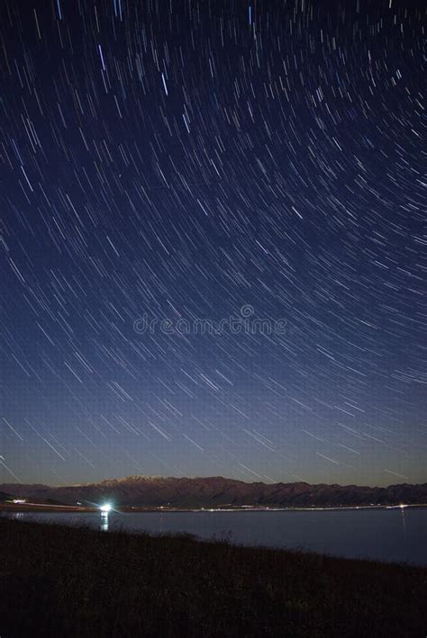 Long Exposure Vertical View Of The Starry Night Hiding Behind The Hill