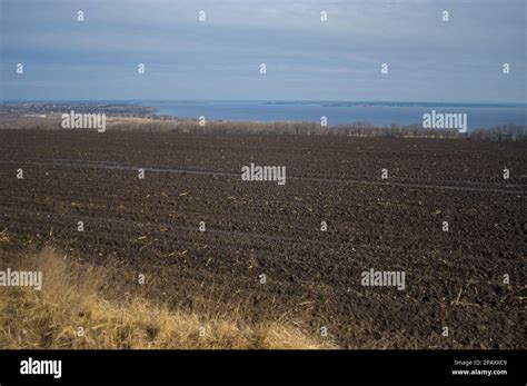 Early Spring Landscape With Agricultural Field Near Dnipro River Down To Outskirts Of