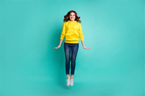 전체 길이 바디 사이즈 사진 의 쾌활 한 좋은 귀여운 달콤한 예쁜 여자 친구 스트레칭 까지 점프 에 청바지 데님 신발 고립 위에 생생한 청록색 색상 배경 로켓에 대한 스톡