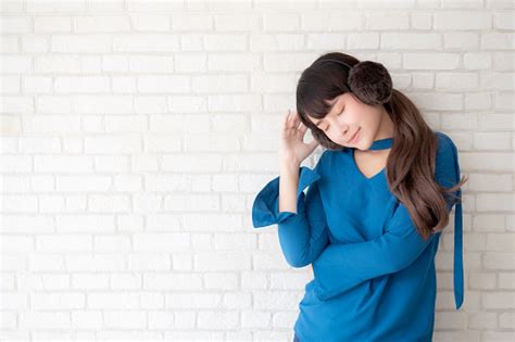 아름 다운 젊은 아시아 여자의 초상화 즐길 수 있는 행복 회색 시멘트 질감 그런 지 벽 벽돌 배경에 서 소녀는 미소와 밝은