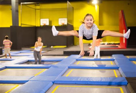 Full Length Of Happy Casual Girl Jumping Spreading Legs On Colorful