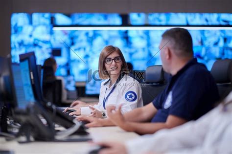 在闭路电视监控室工作的一组安全数据中心操作员查看多个监视器合照美女高清摄影大图 千库网
